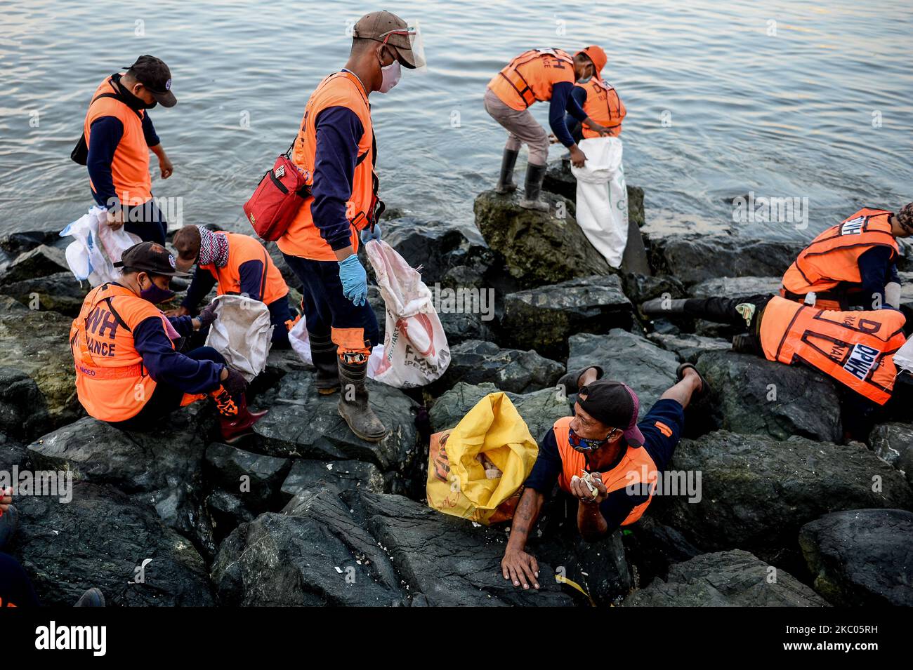 Workers clean a portion of Manila Bay in celebration of International ...