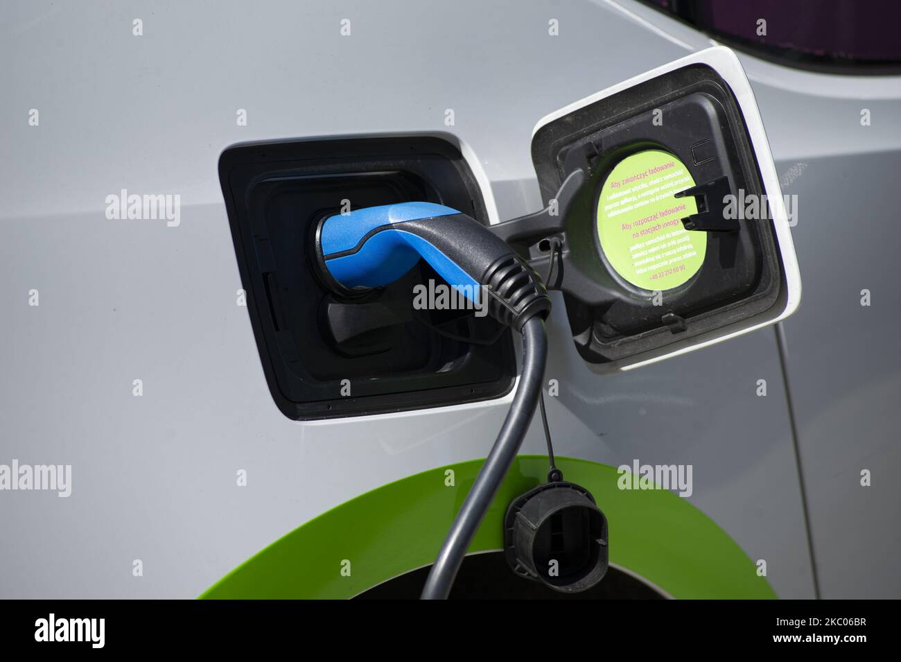 A charging plug is seen plugged into a BMW i3 electric car on September ...