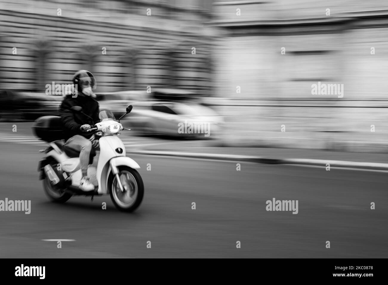A grayscale of a man speeding on a motorbike Stock Photo - Alamy