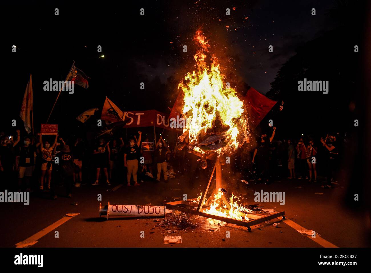 Activists raise their closed fists as an effigy portraying Philippine ...
