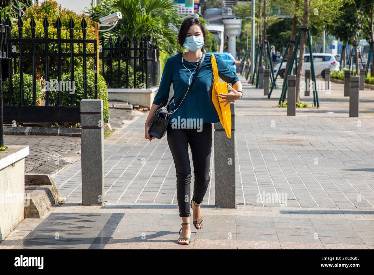 A worker walking at Sudirman Street, South Jakarta despite the ...