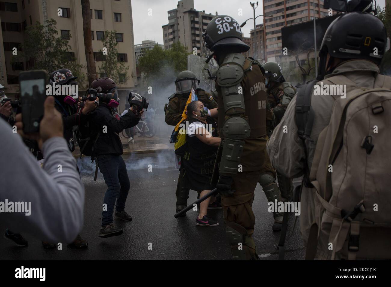 An older adult woman is strongly detained by riot police just for ...