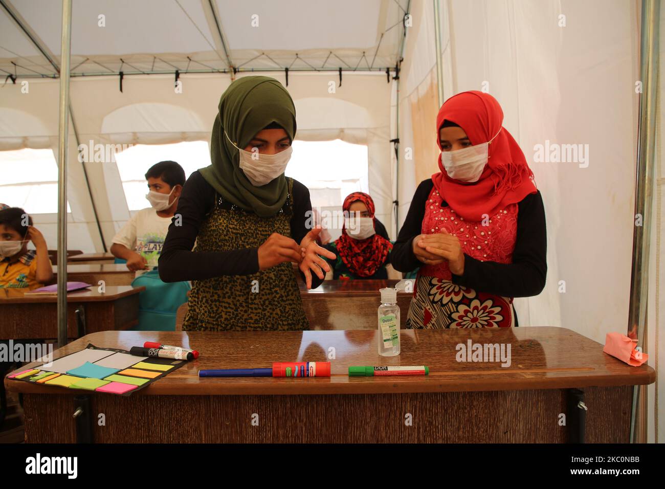 Syrian students wearing protective masks sit on their seats during the ...