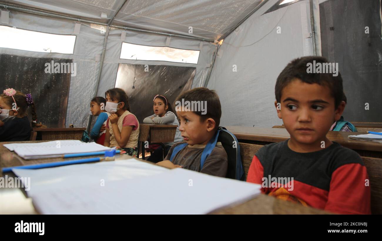 Syrian students wearing protective masks sit on their seats during the ...
