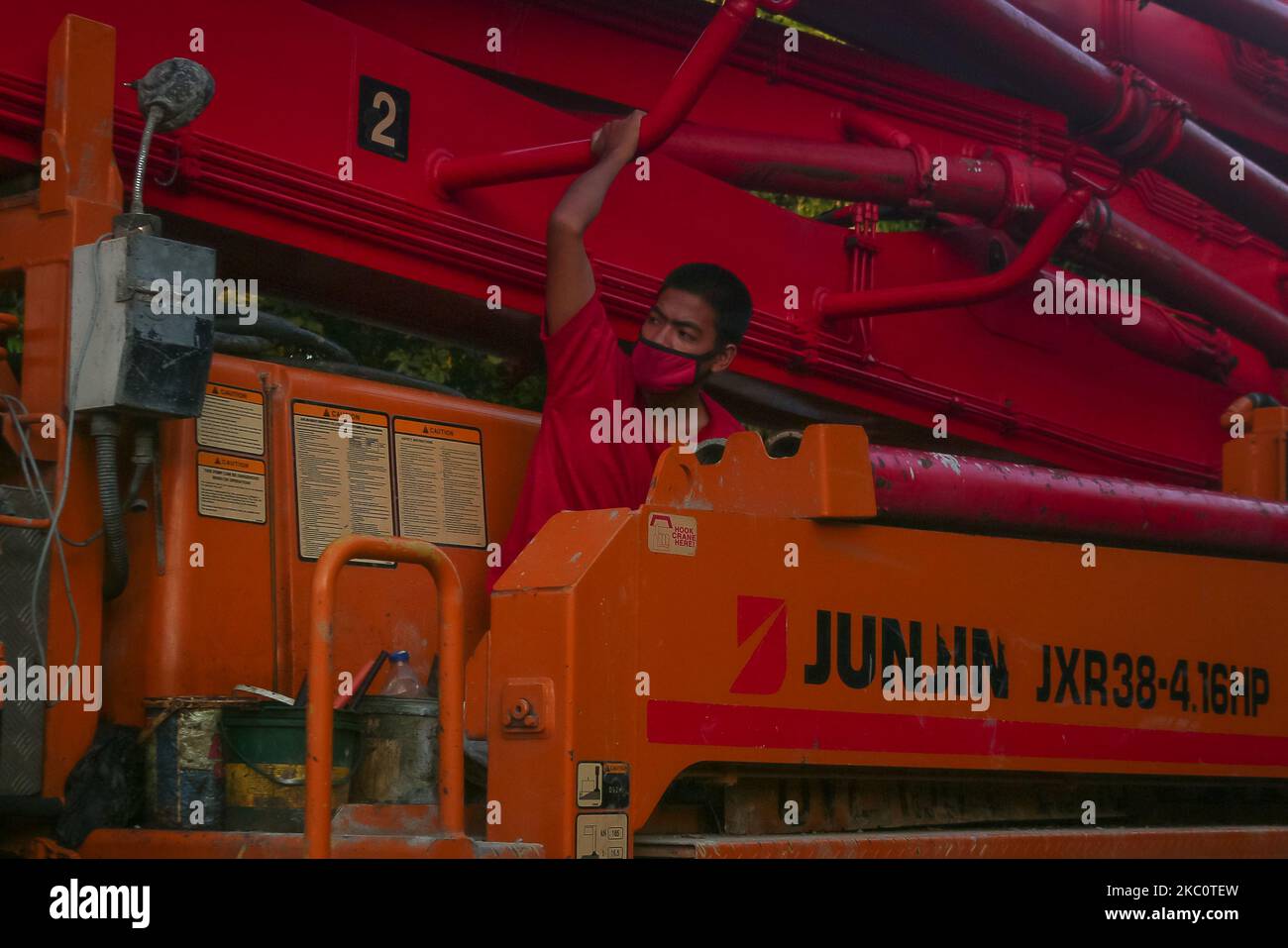A man in Antipolo City is riding at the back of the concrete pump truck ...