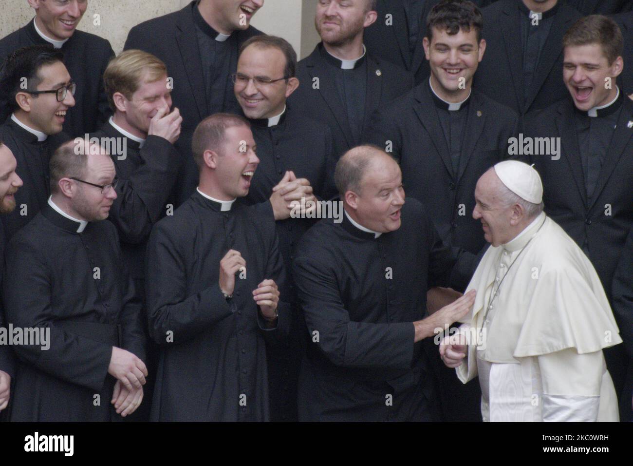 A group of seminarians make the signs of the cross as they are greeted ...