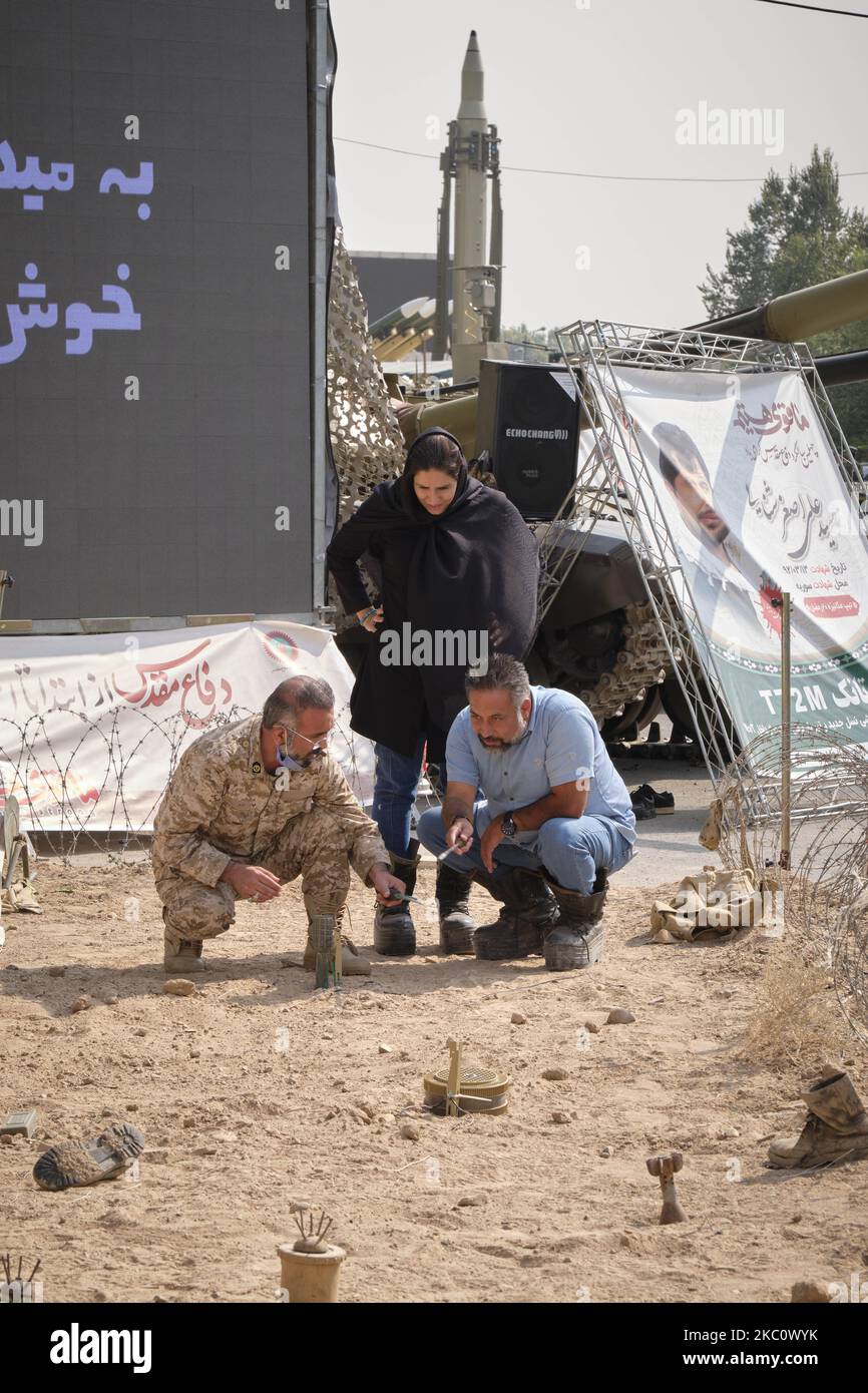 A member of the Islamic Revolutionary Guard Corps (IRGC) (L), explains ...
