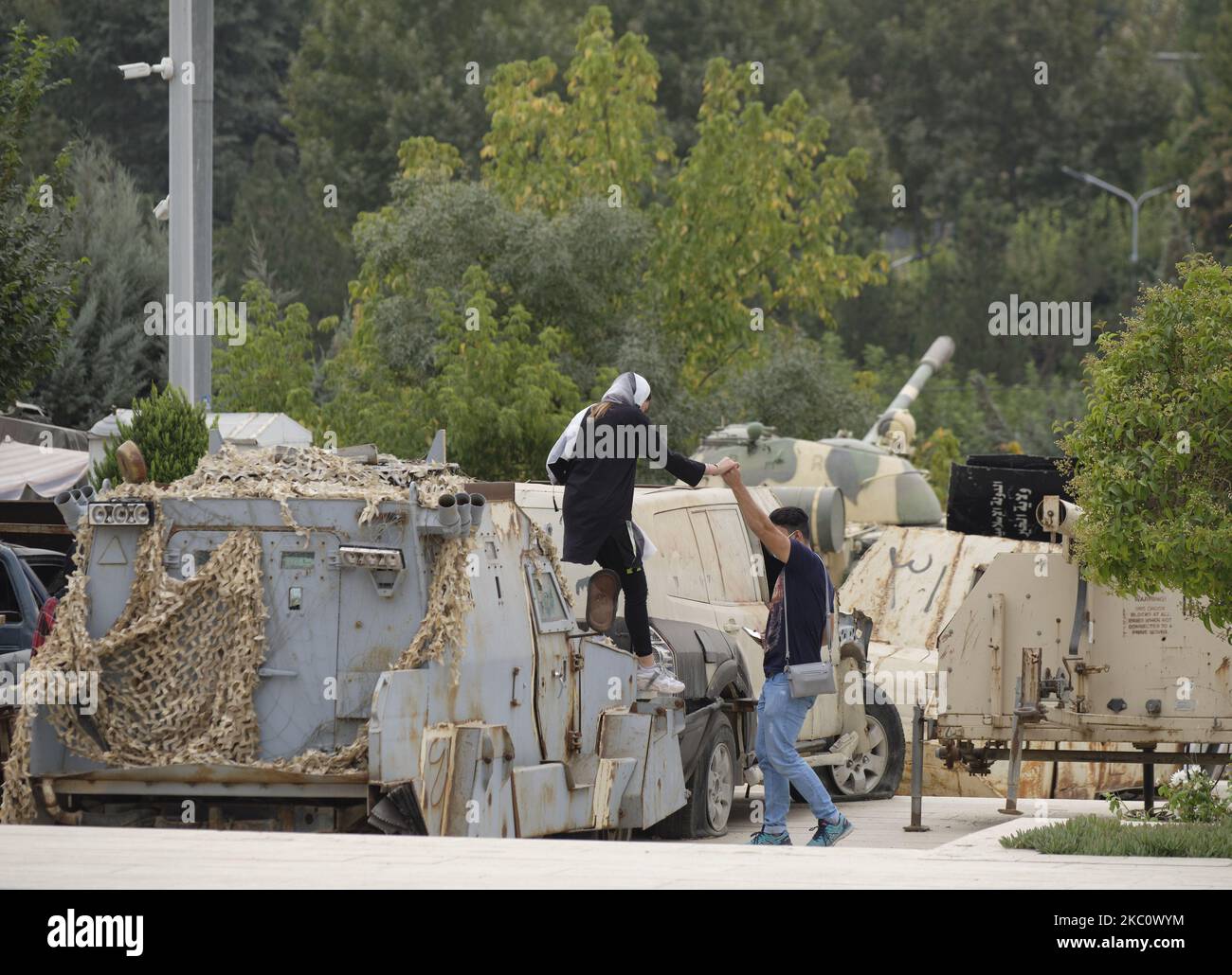 An Iranian man helps his relative to come down from an exploded car ...