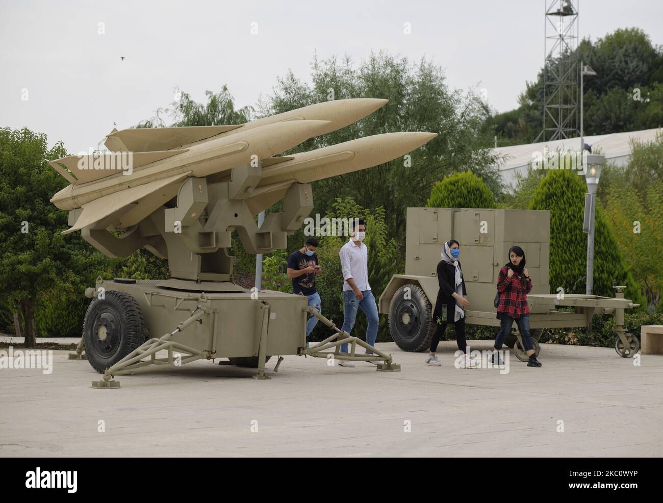 Iranian youth walk past anti-aircraft missiles while visiting of the ...
