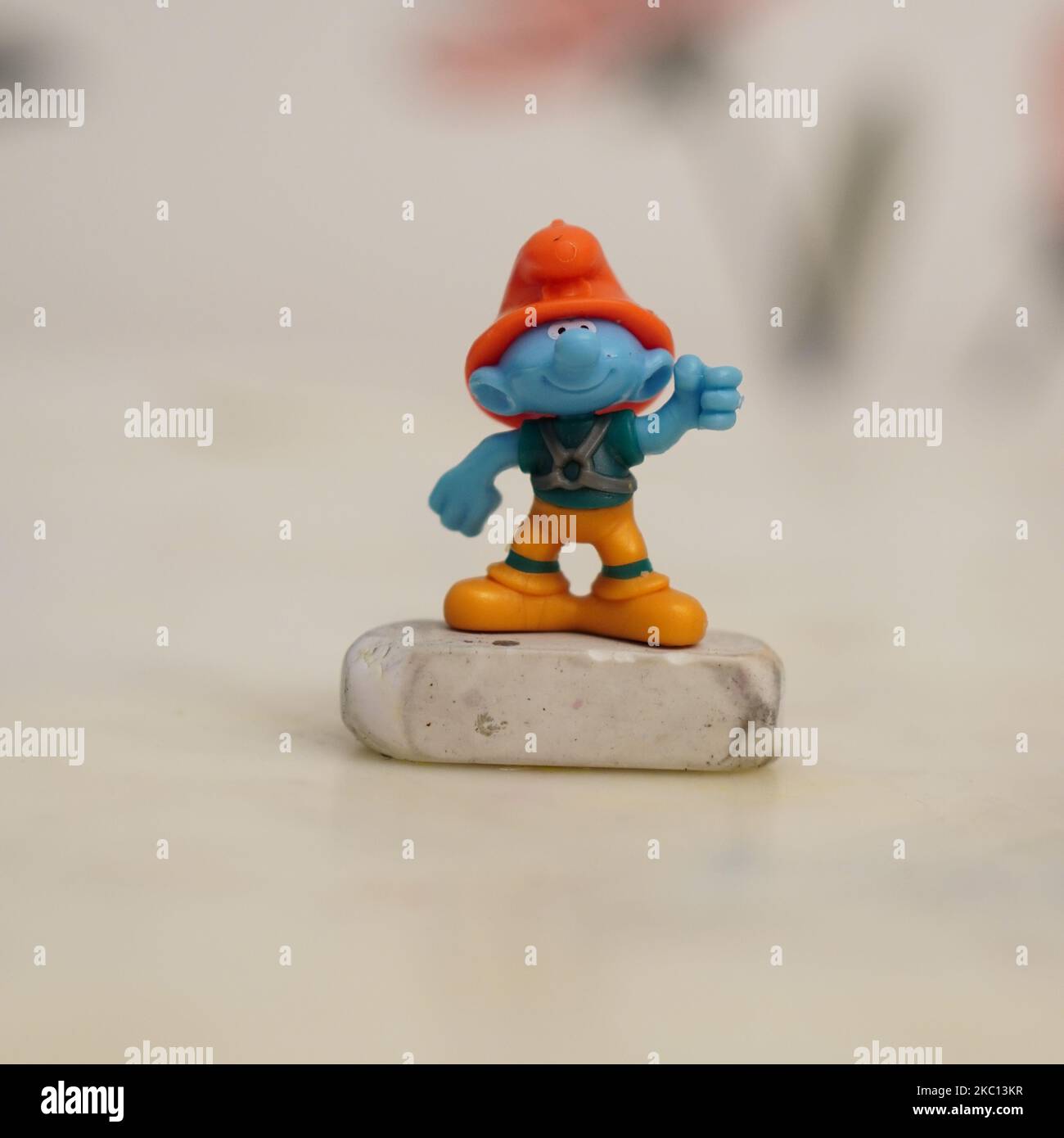 A blue Smurf toy figurine standing on a used eraser Stock Photo - Alamy