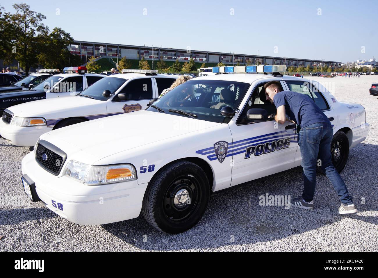 A man looks inside a Ford Crown Victoria car during the American Police ...