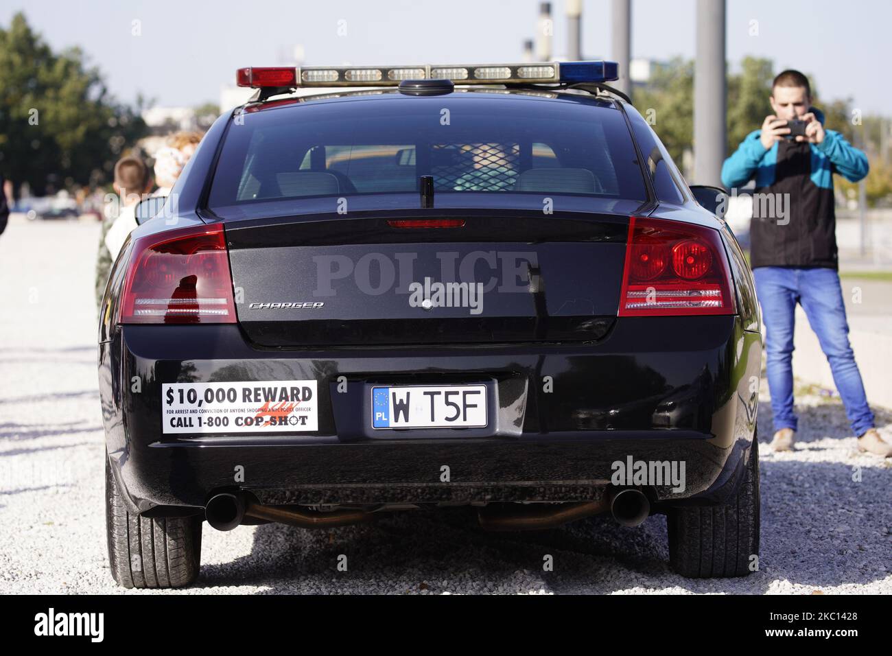 A man takes a photo of a Dodge Charger during the American Police Car ...