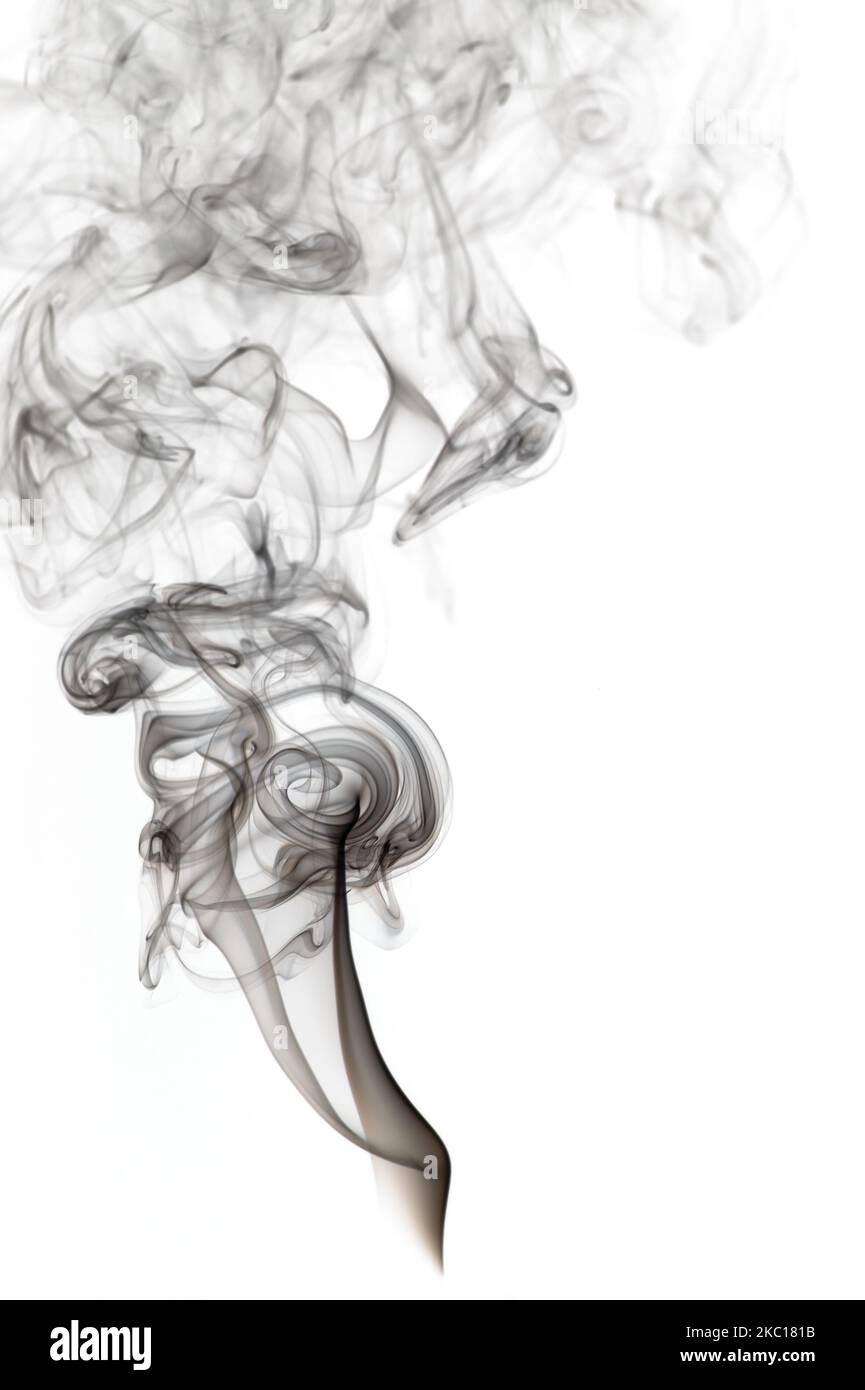 Puffs and curls of dark smoke on a white background rising from a ...
