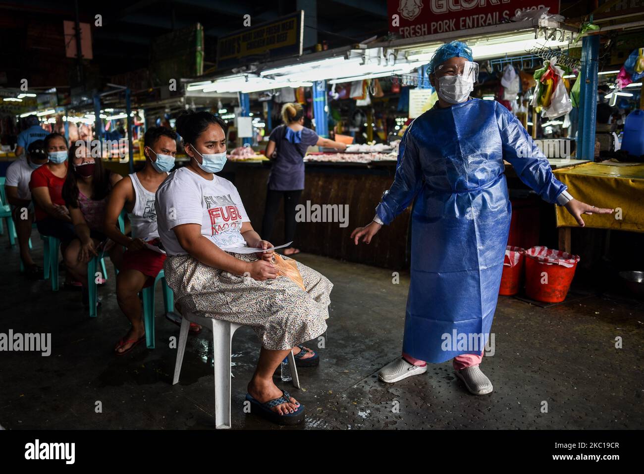 Market vendors queue as they wait before undergoing x-ray procedures at ...
