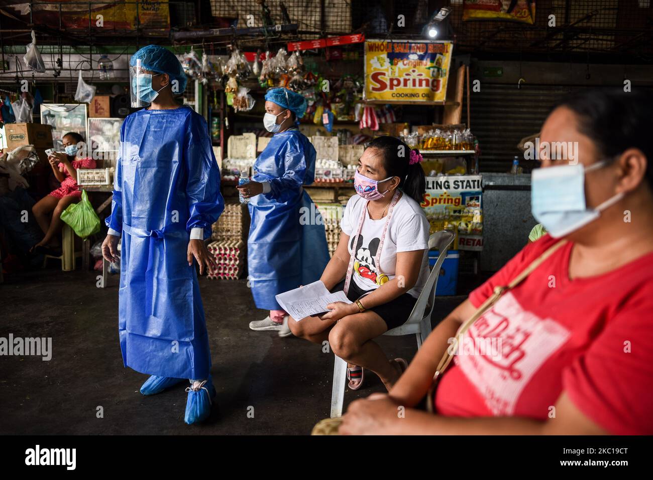 Market vendors queue as they wait before undergoing x-ray procedures at ...