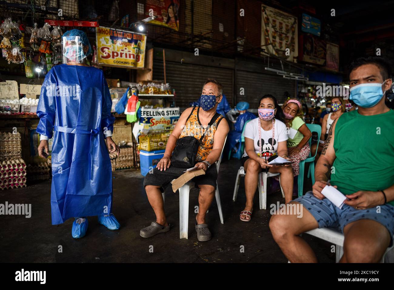 Market vendors queue as they wait before undergoing x-ray procedures at ...