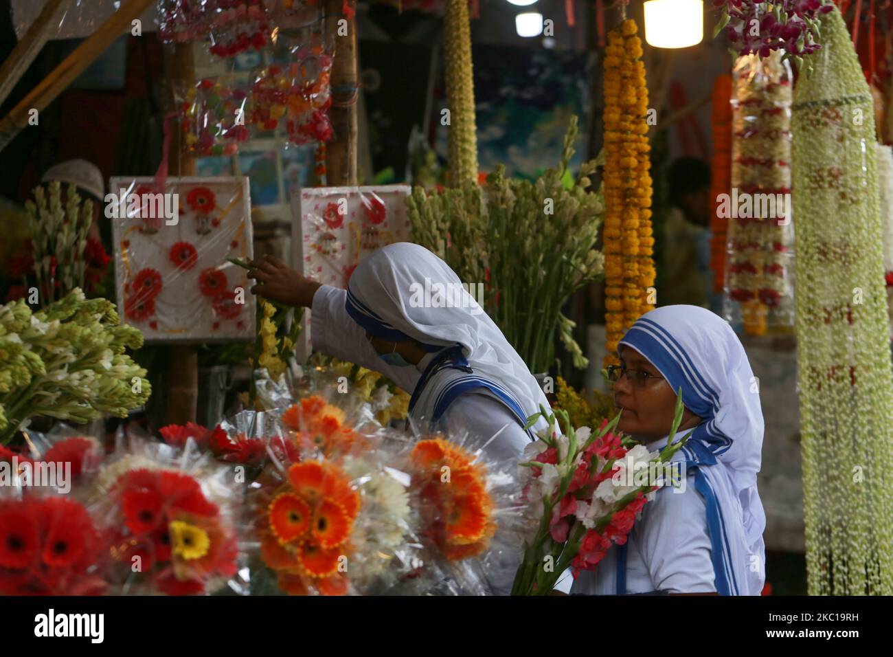 Women buy flowers from a stall in Dhaka, Bangladesh on October 6, 2020 ...