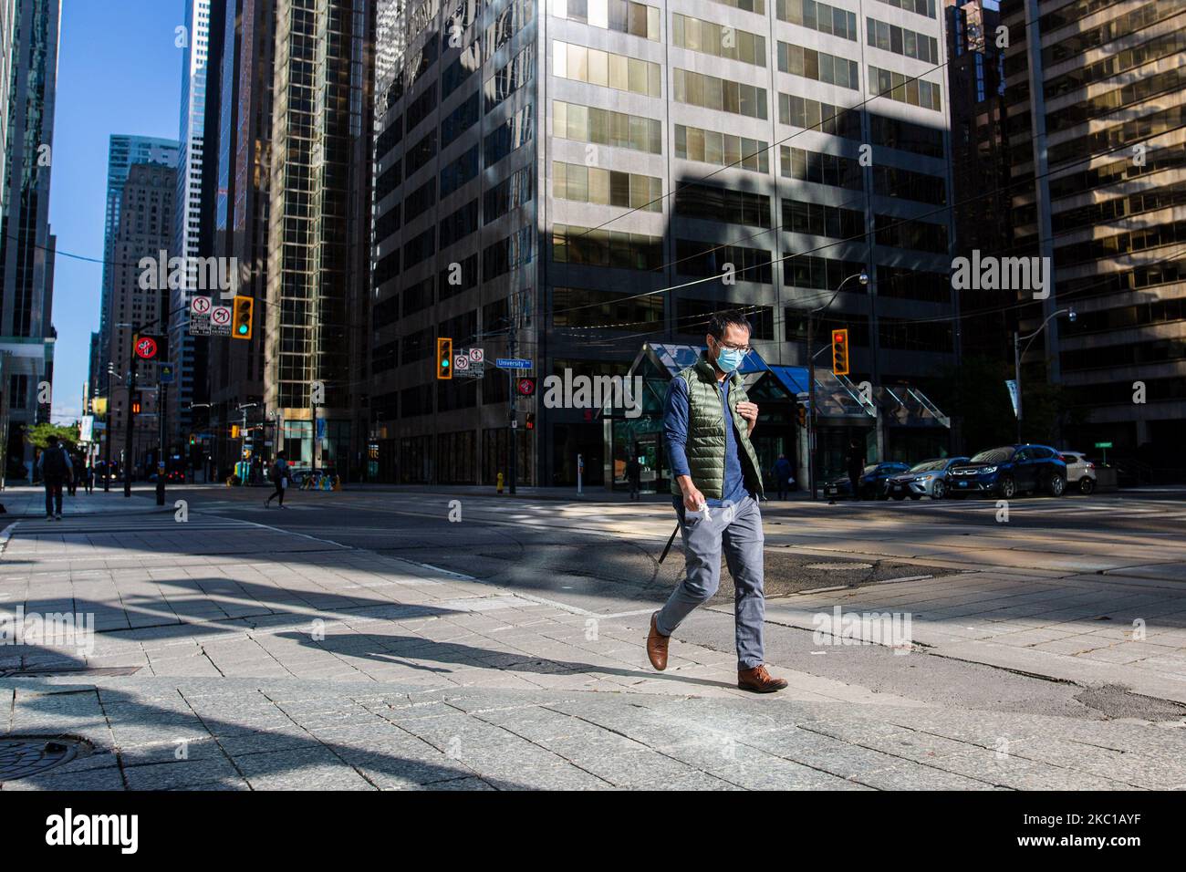 A person walks through a largely empty University and King intersection ...