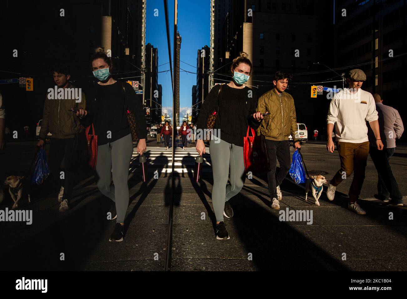 People are reflected as they walk through Toronto's financial district ...