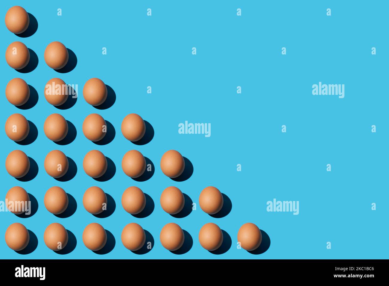 A pattern of brown chicken eggs lying diagonally on the left half of ...