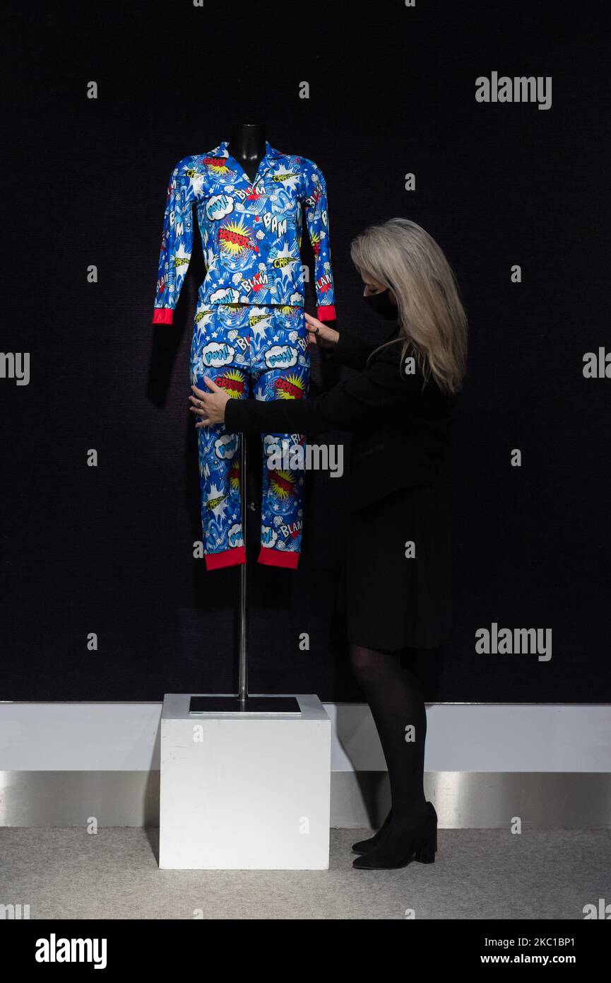 A staff member poses with the pyjamas worn by Jodie Comer as Villanelle ...
