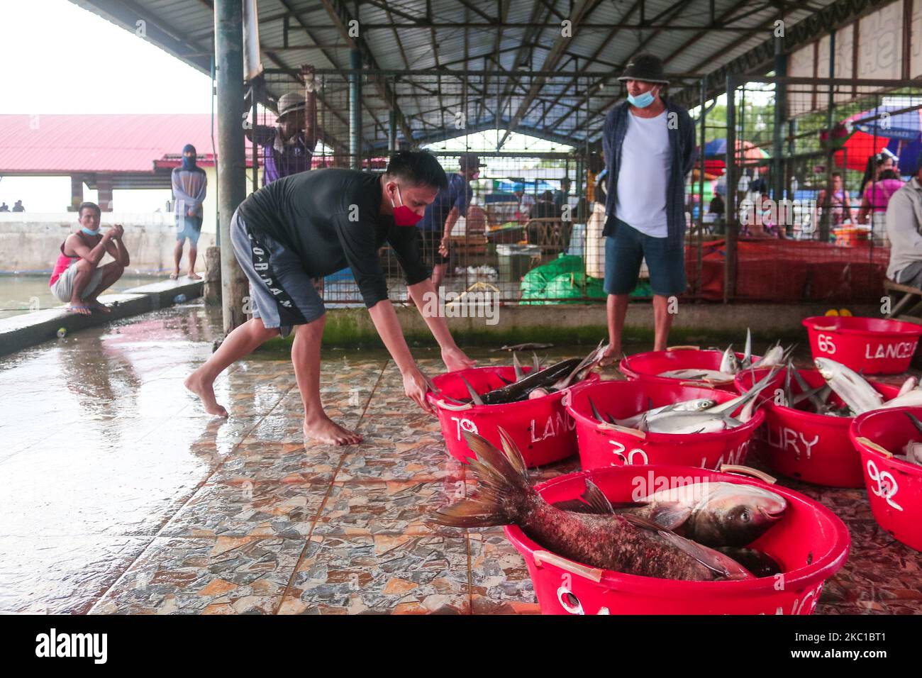 A group of fish porter in Binangonan, Rizal are unloading the basin ...
