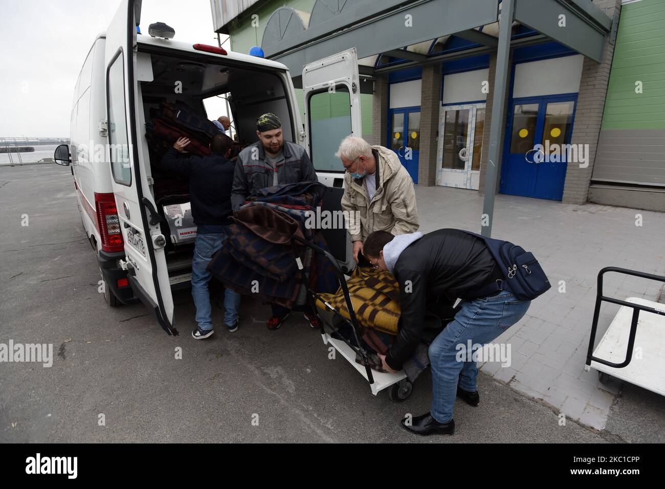 Workers unload blankets brought to a temporary medical facility for ...