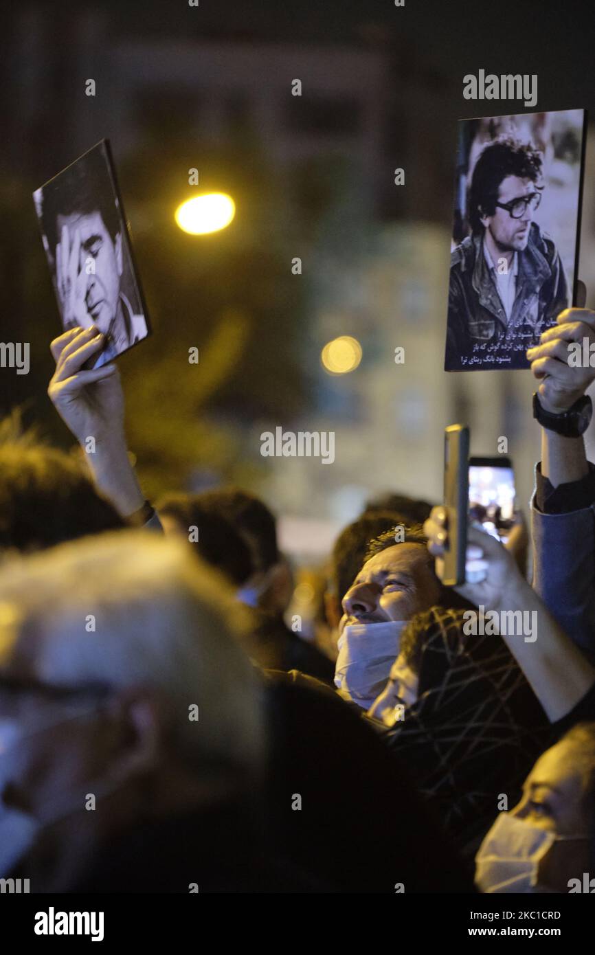 An Iranian man holds-up portraits of the Iranian iconic vocalist master ...