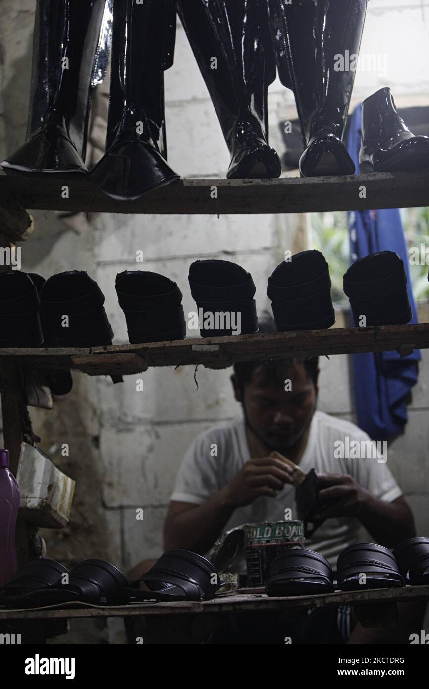 An employee works on shoes at a home Belinda shoes factory in Ciomas ...