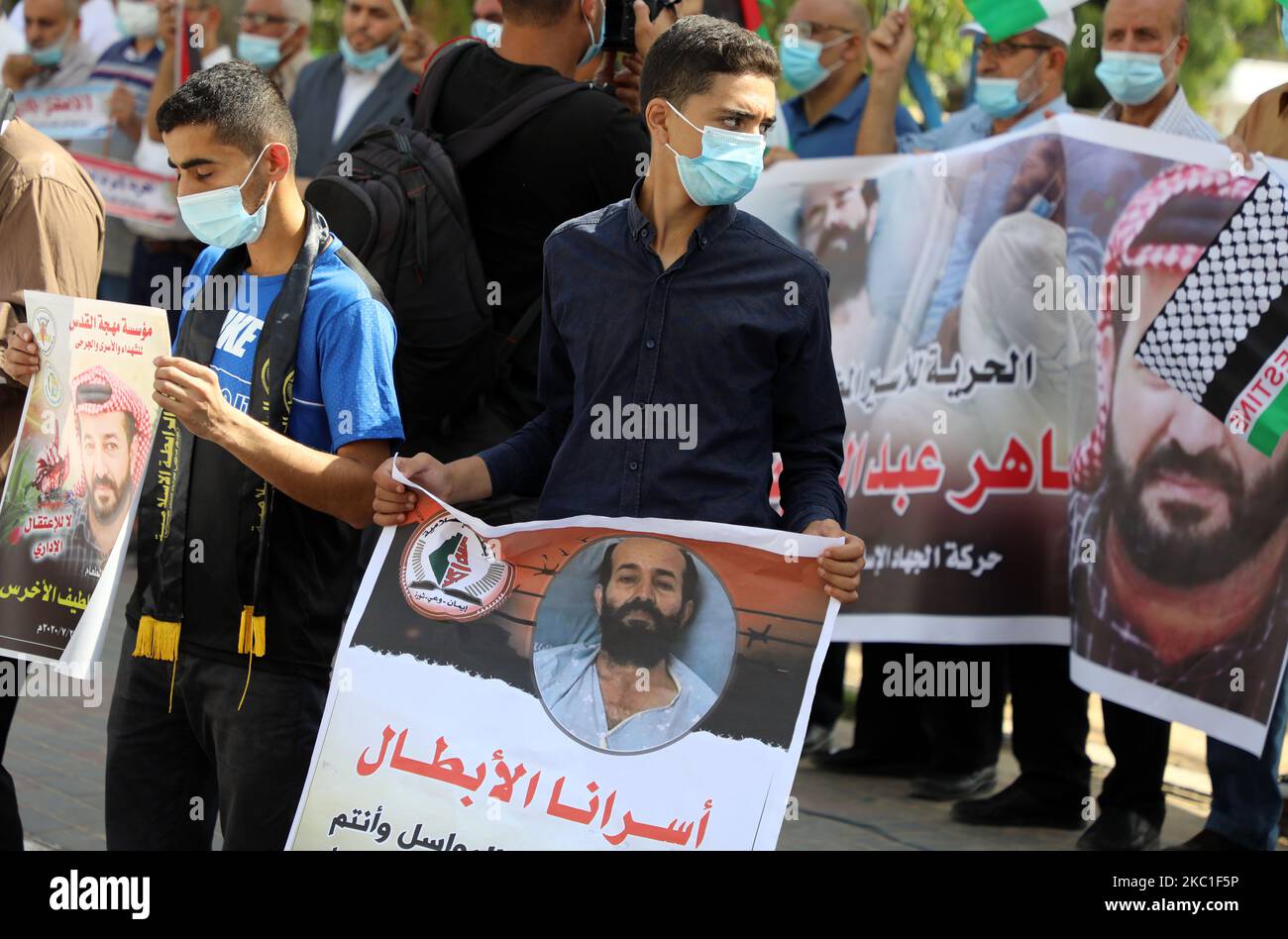 Palestinians hold posters depicting Palestinian prisoner Maher Al ...