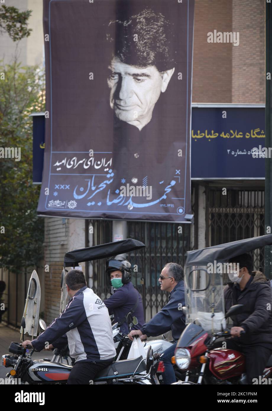 Motorcyclists stop under a portrait of the Iranian iconic vocalist ...