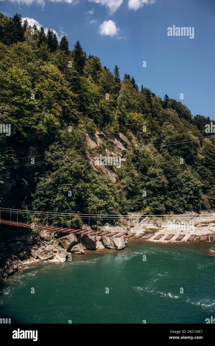 The beautiful view of a wood drawbridge and the Carpathians mountain in ...