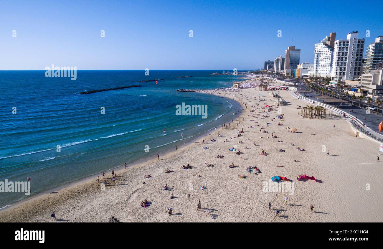 Aerial view of people bathing in the sun, swimming and playing games on ...