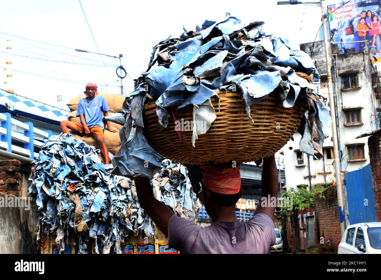 Indian worker carrying tanned animal hides to lode a truck at a tannery ...