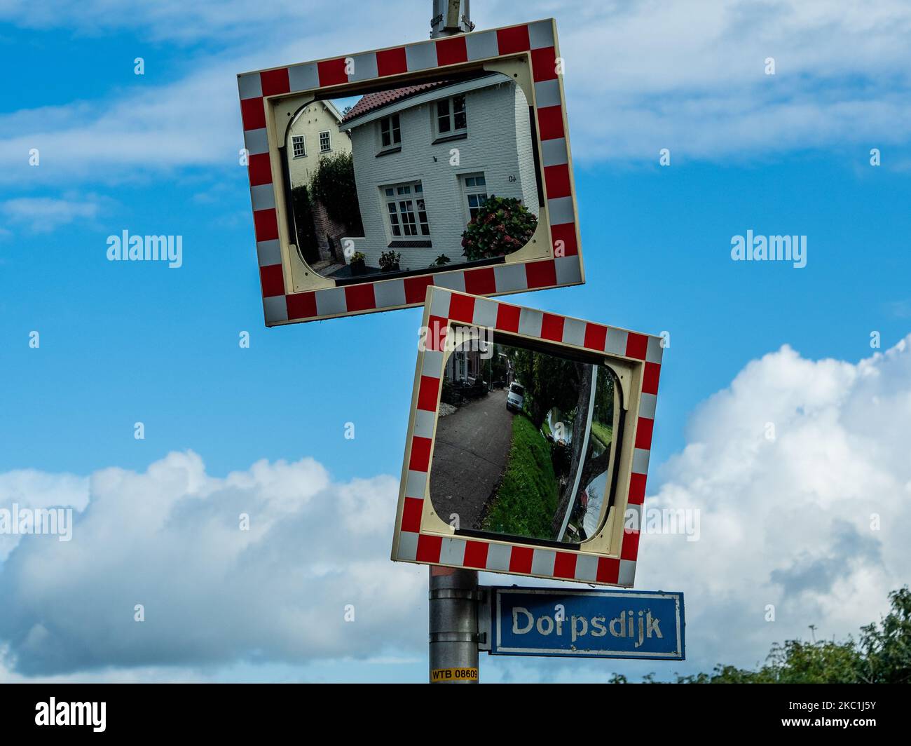 A couple of mirrors are placed in an intersection on the street to ...