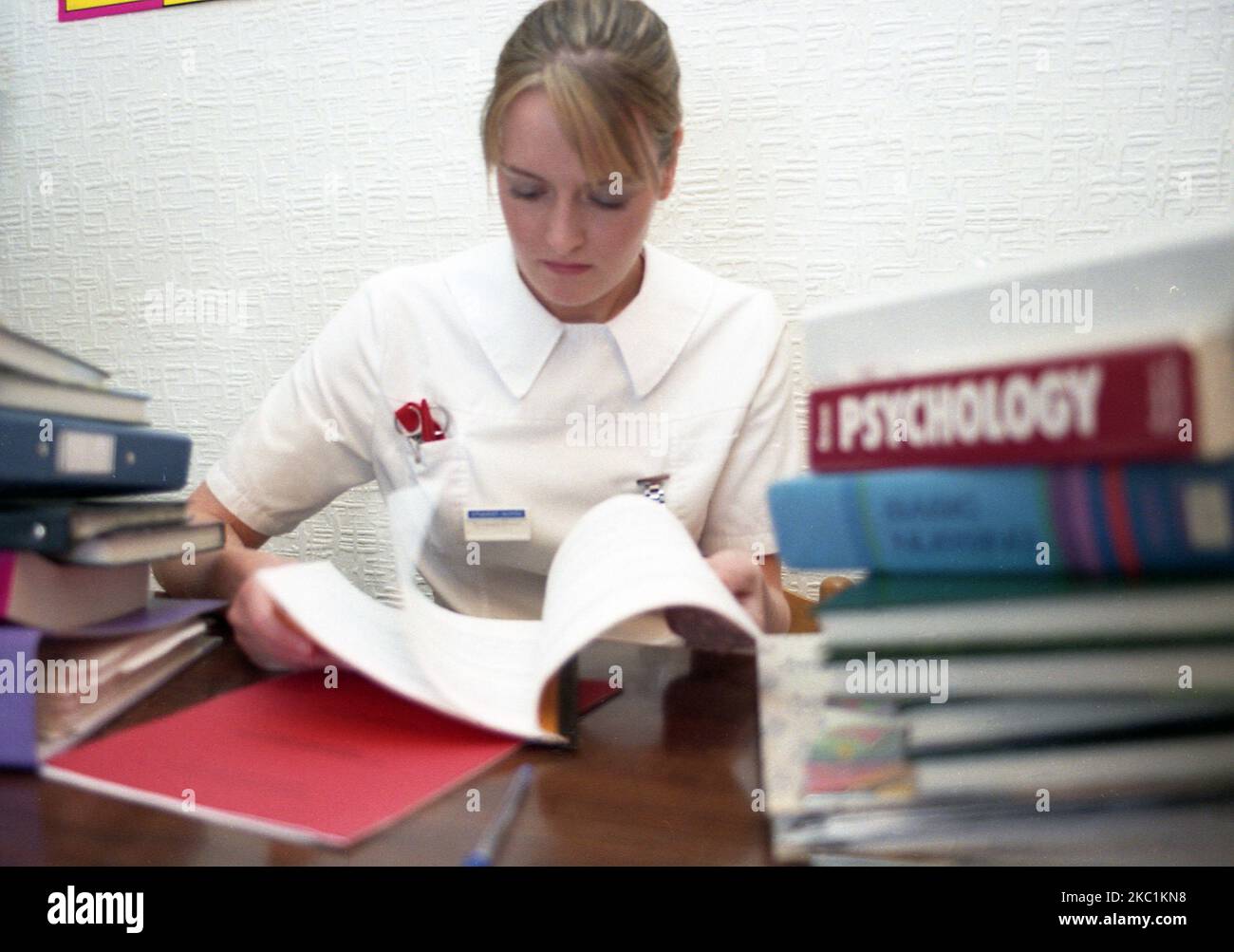 1990s, wearing a white nursing top, watch on chain and badge, a young ...