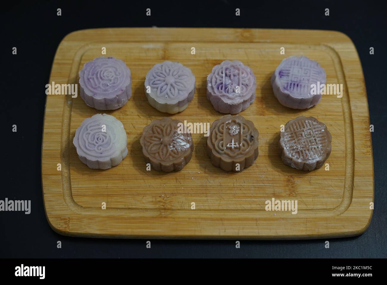 A top view of pandan snow skin mooncakes served on a wooden serving ...