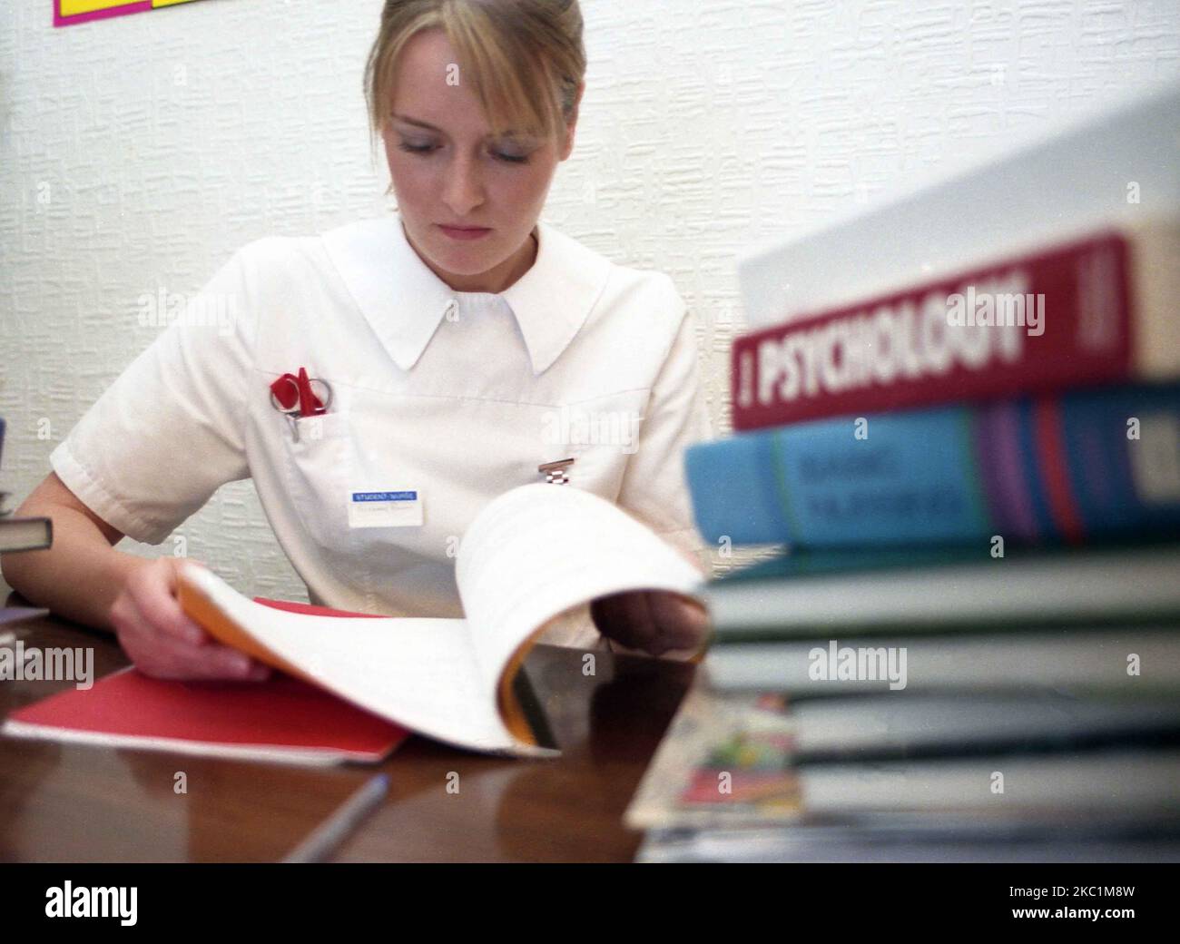 1990s, wearing a white nursing top, watch on chain and badge, a young ...