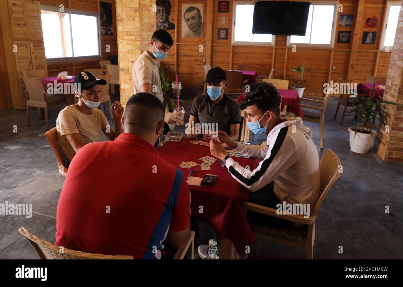 Youths play cards at a beach side cafe in Gaza City, Monday, Oct. 12 ...