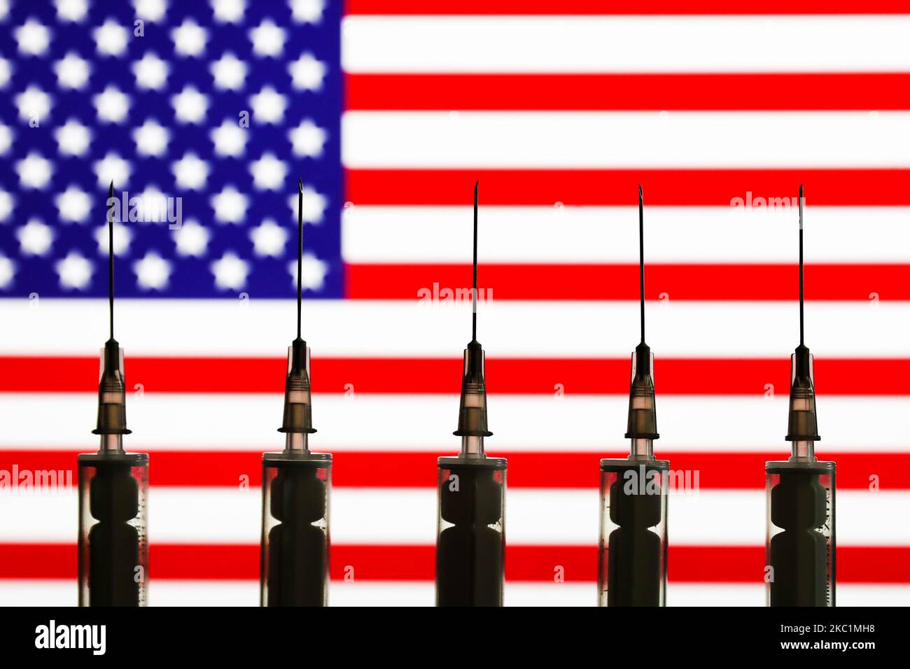 Medical syringes are seen with American flag in the background in this ...