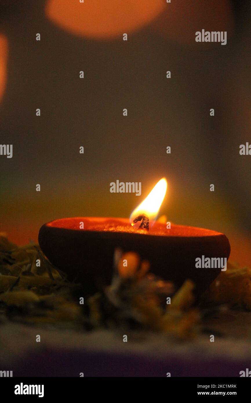 A vertical closeup of a lit diya lamp at home at night for Diwali Stock ...
