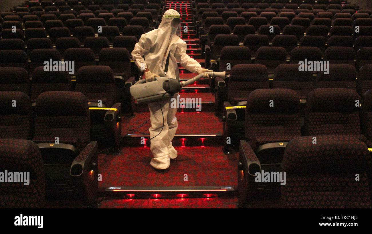 A worker sanities inside a theatre hall ahead of the scheduled ...