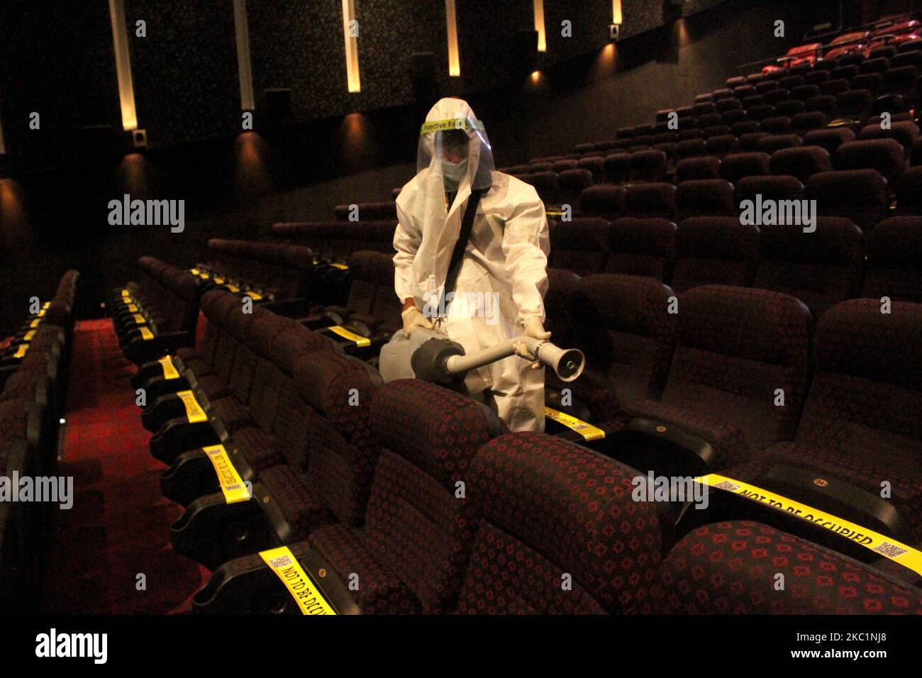 A worker sanities inside a theatre hall ahead of the scheduled ...