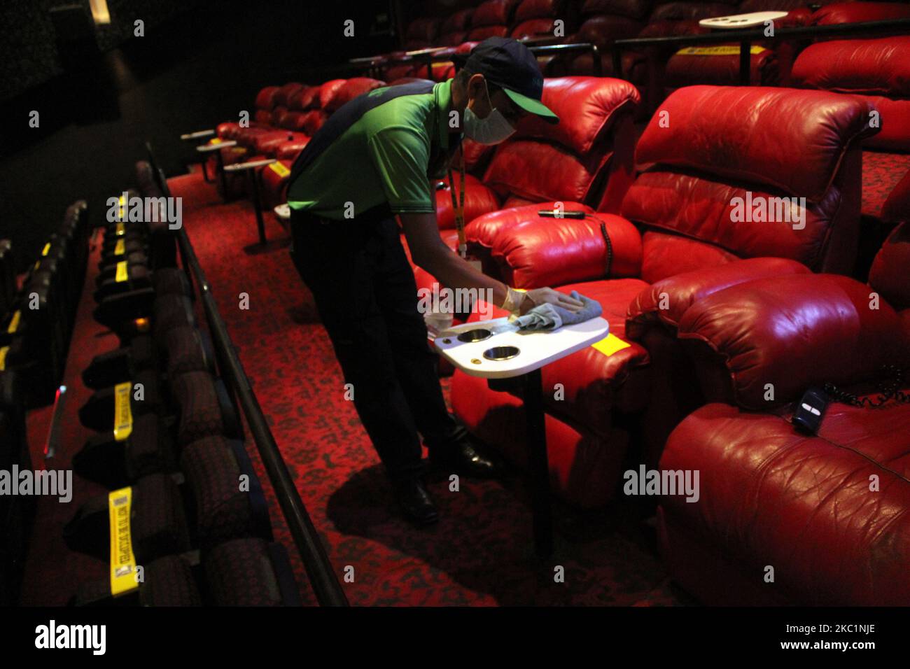 A worker sanities inside a theatre hall ahead of the scheduled ...