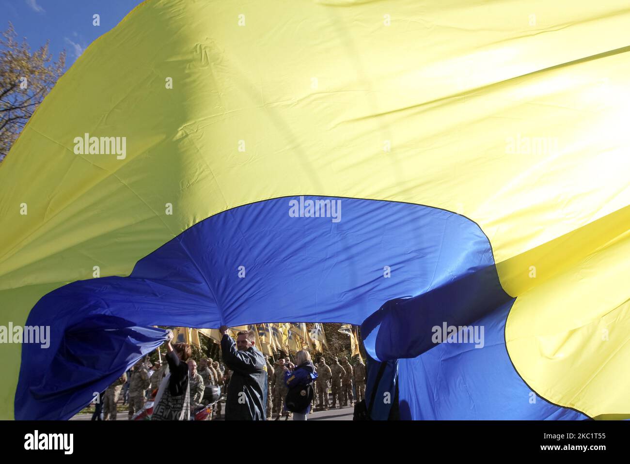 Ukrainians wave a large Ukrainian flag during a march to the 78th ...