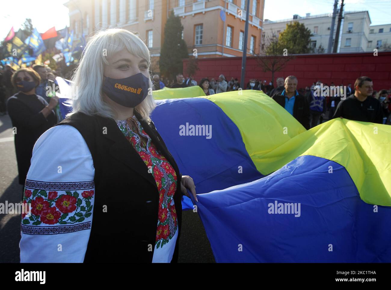 People carry a large flag of Ukraine during a march to the 78th ...