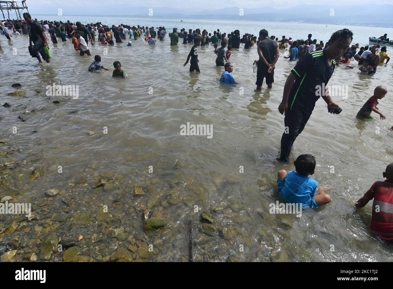 A number of residents wet their bodies with sea water while ...