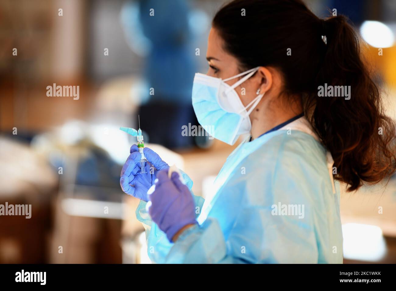 A nurse prepares to administer a flu vaccination at a temporary ...