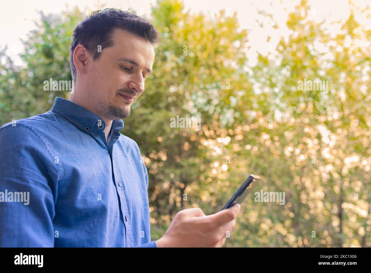 Happy man walking in autumn park and smiling. Young man looking at ...