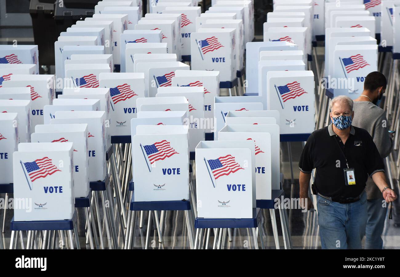 Election workers set up voting booths at an early voting site ...